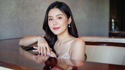 An elegant, scantily clad Eastern woman sits rel